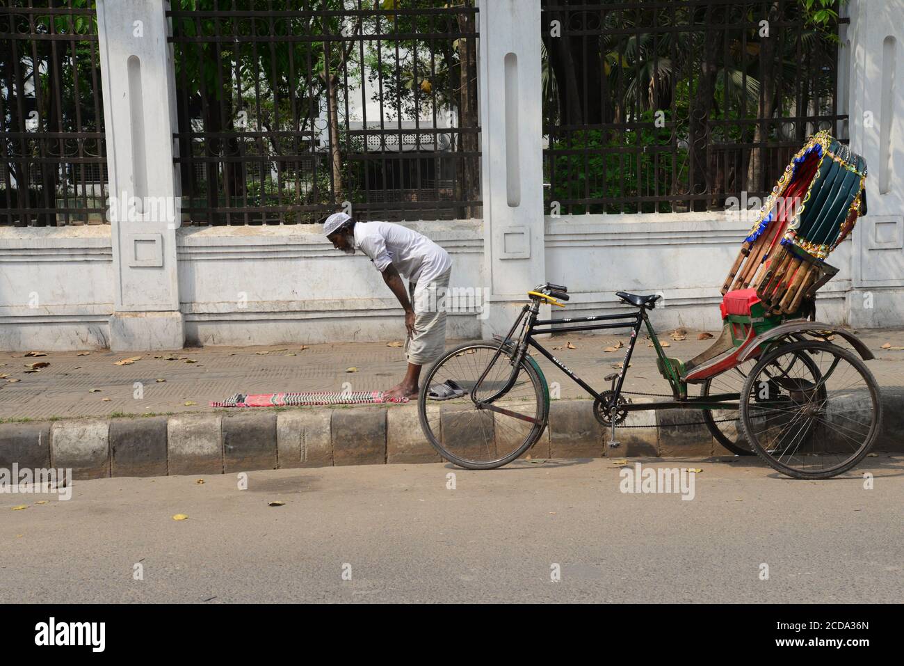 A Bangladeshi Muslim Rickshaw driver offer prayer on the street in ...