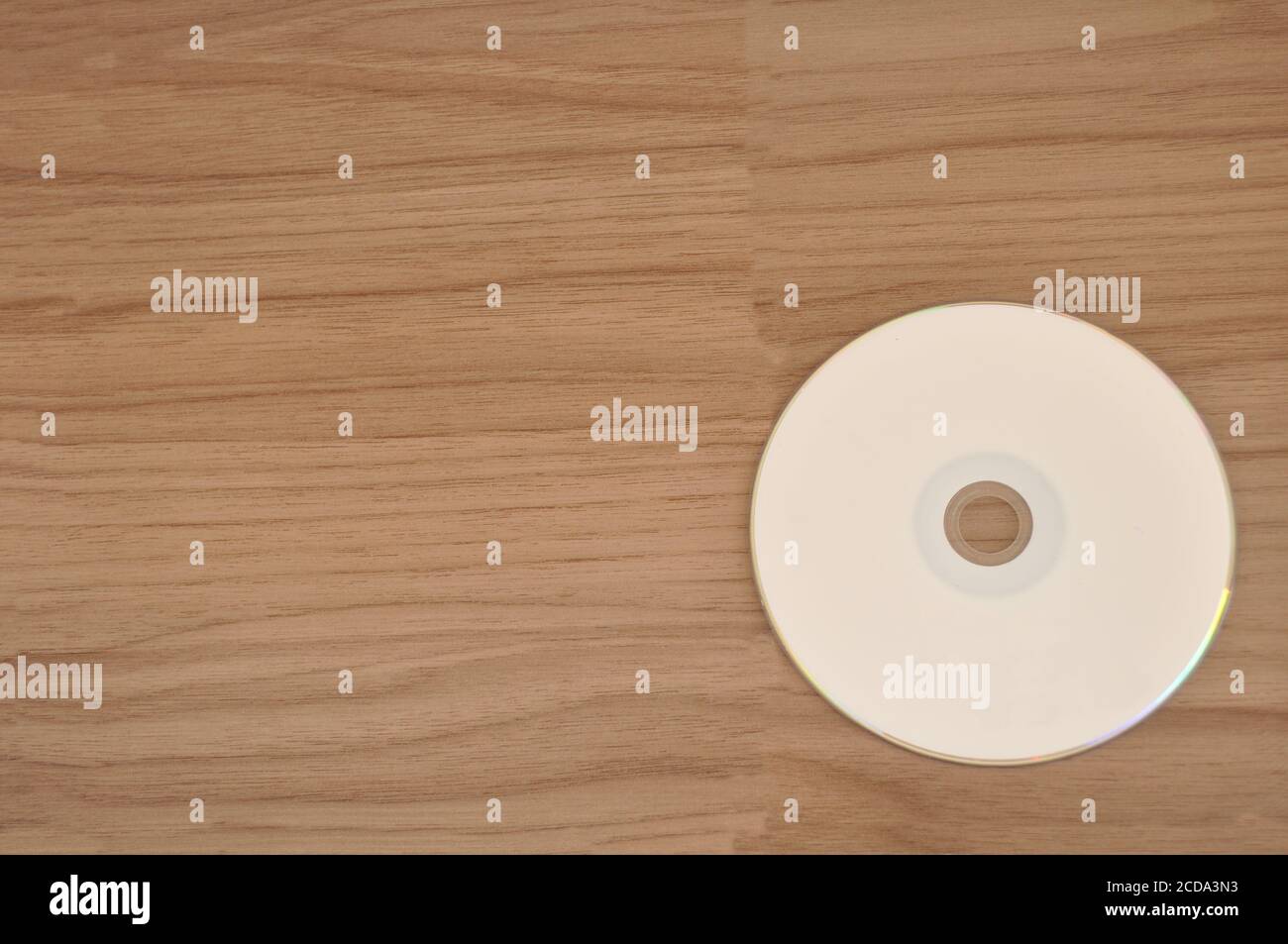 White DVD disc on wooden background blank DVD for recording movies and ...