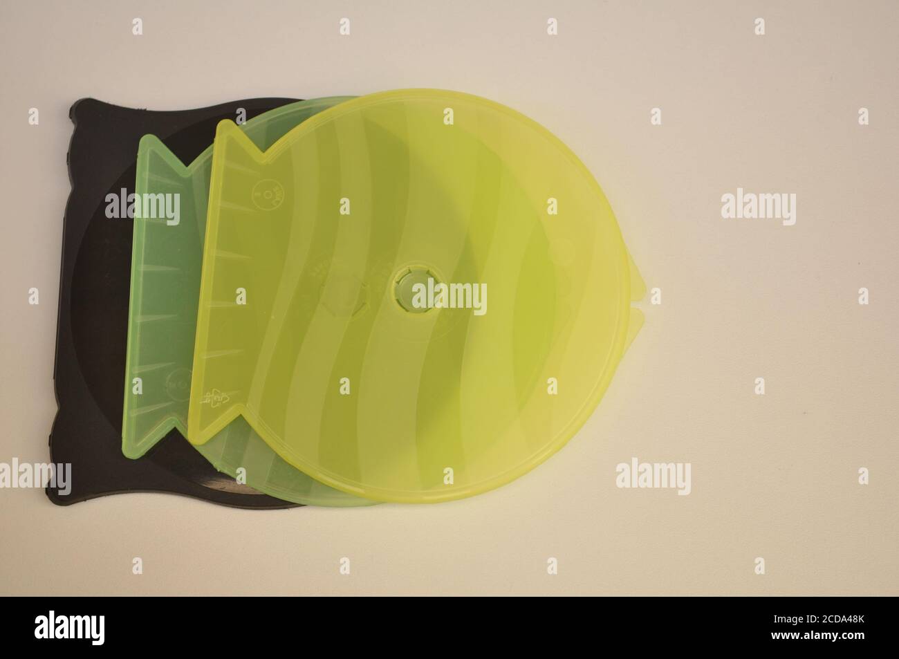 Plastic cd and dvd covers in fish format in different colors on white ...