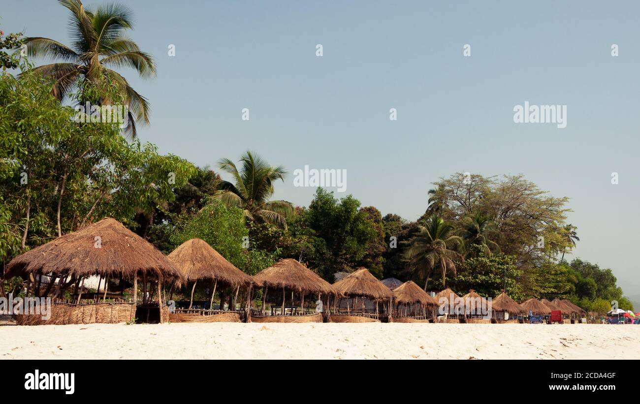 Grass huts aligned in front of the beach Stock Photo - Alamy