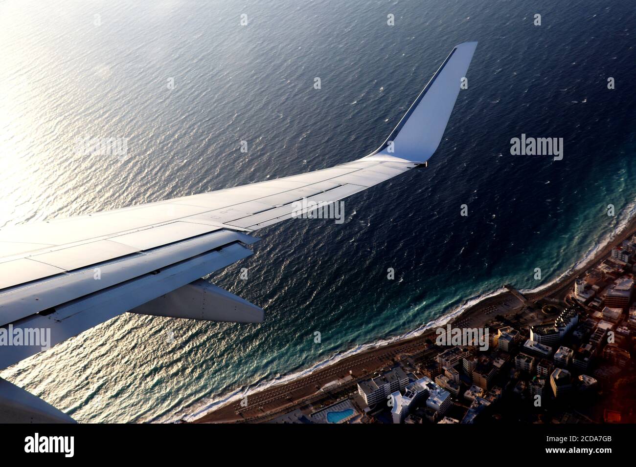 Airplane wing flying above greek town Stock Photo - Alamy