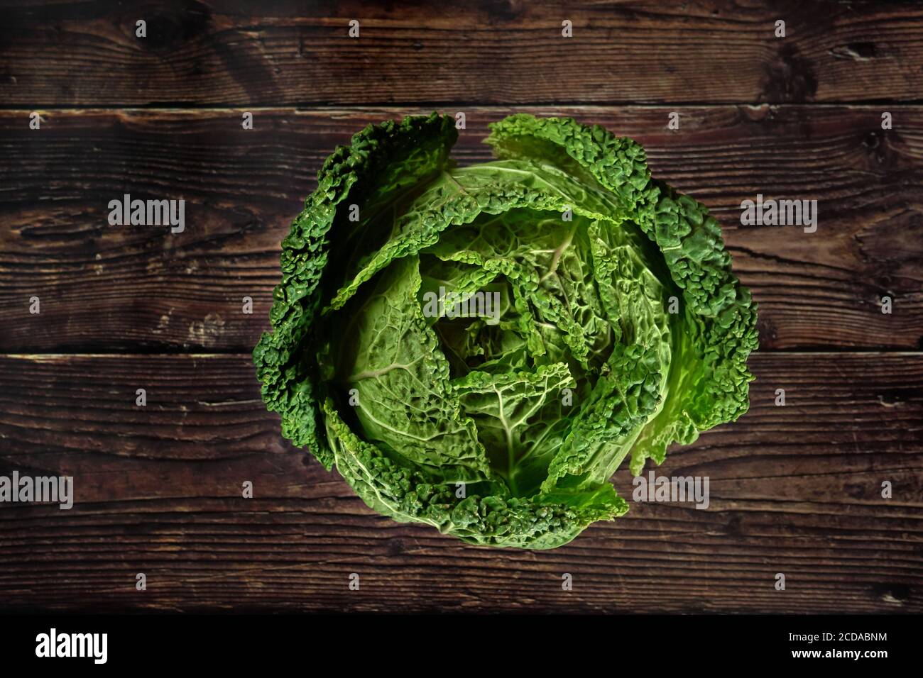 Top down view, savoy cole cabbage on dark wooden board Stock Photo - Alamy