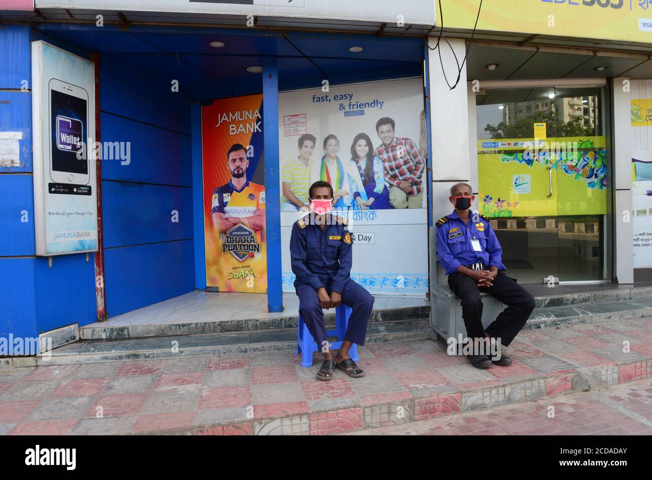 Private security guard at an ATM booth wearing a facemask as a ...