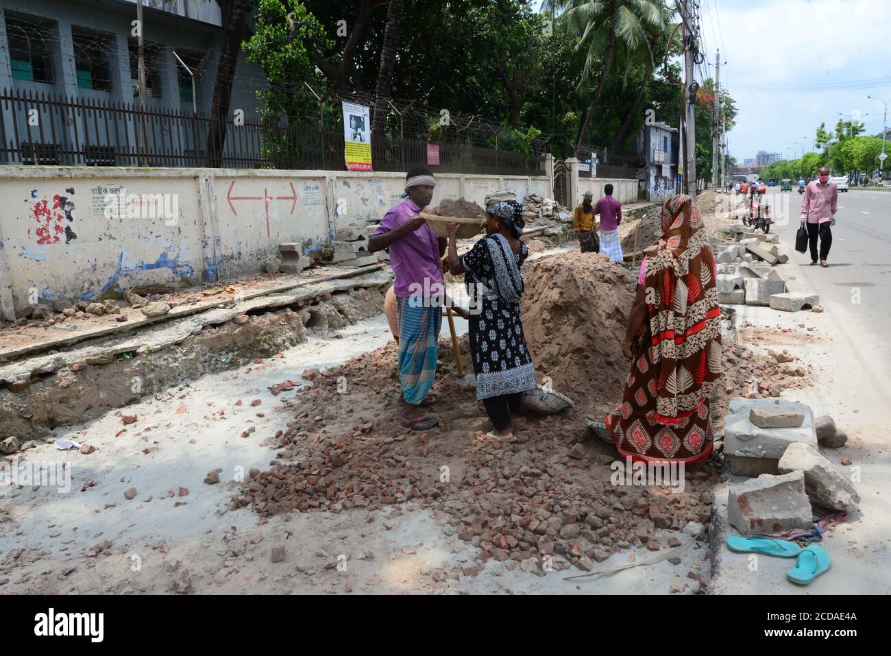 Bangladeshi Daily Labor works without facemask at a road construction ...