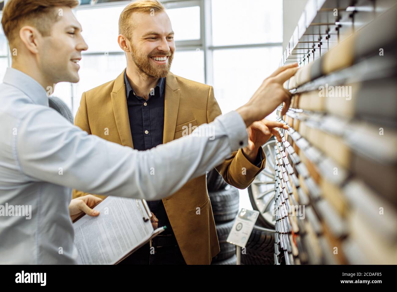 young caucasian customer and consultant look at colors palette, choose ...