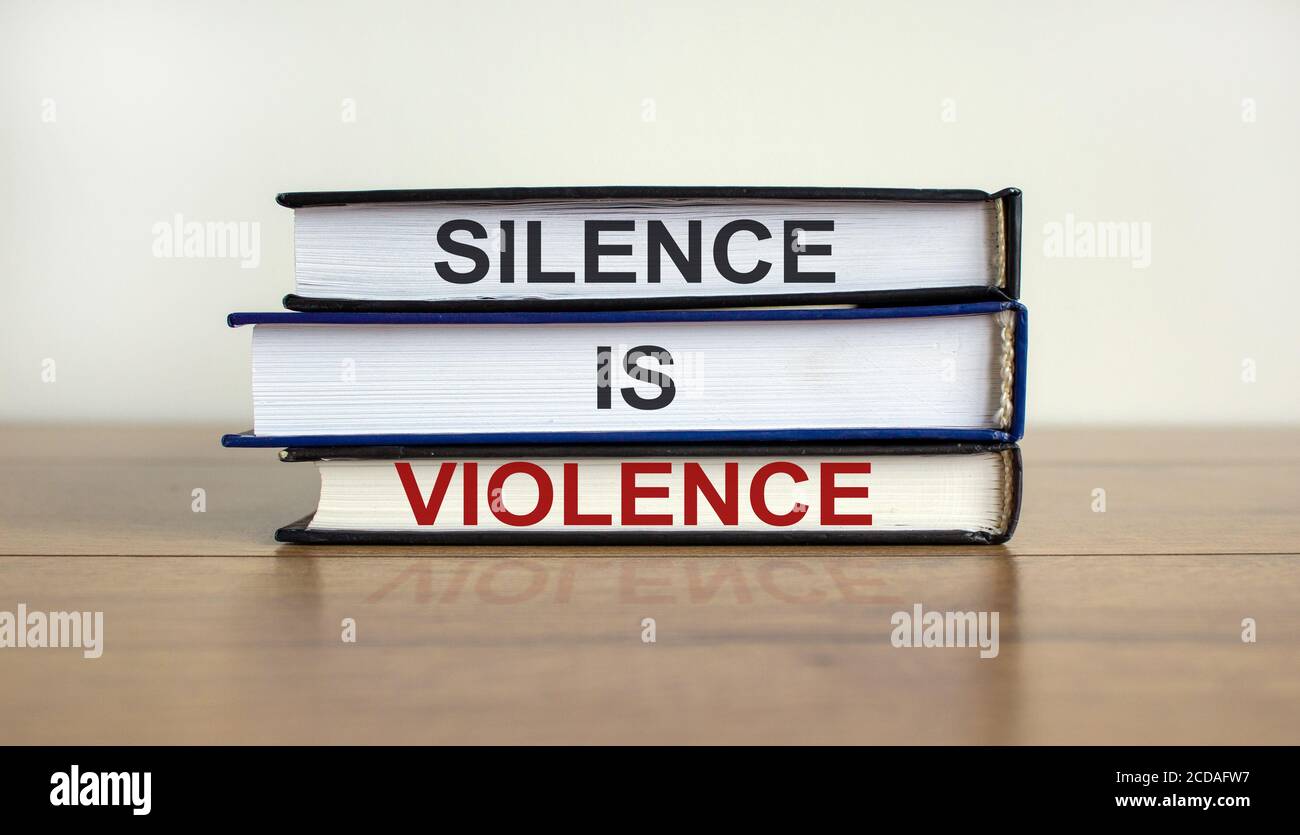 Books with text 'silence is violence' on beautiful wooden table. White ...