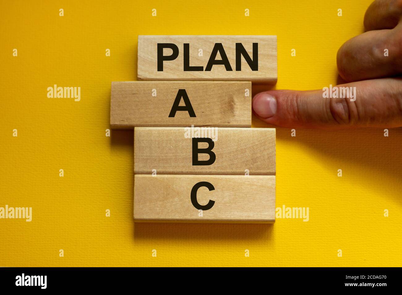 Time to Plan A. Wooden blocks form the words 'plan, A, B, C,' on yellow ...