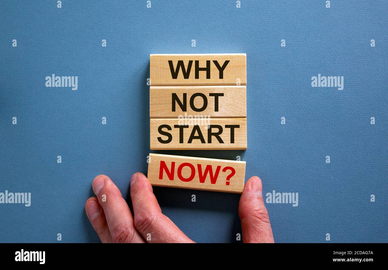 Male hand placing a block with word 'now' on a blocks tower with words ...