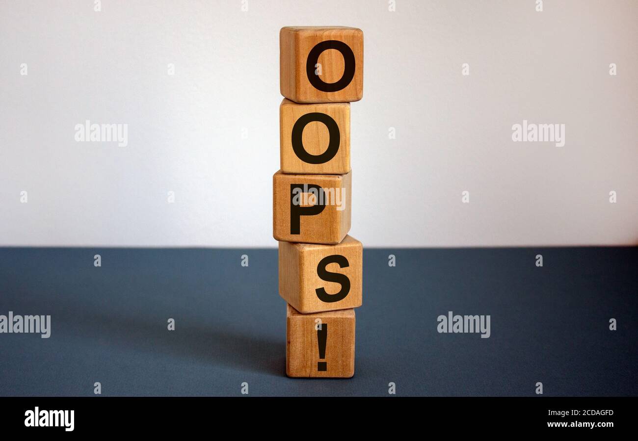 Oops sign on wooden cubes. Beautiful blue table, white background, copy ...