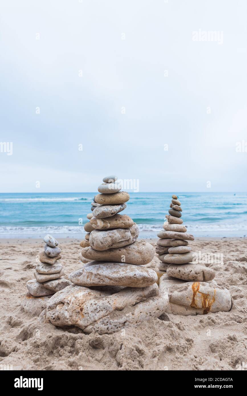Vertical shot of pebbles stacked on each other in a balance at the ...