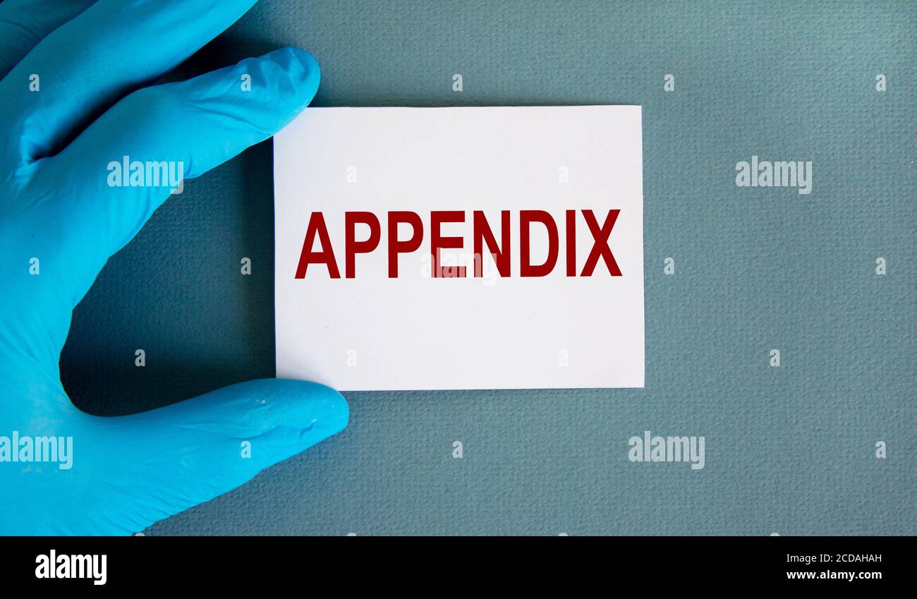 Hand in blue glove with white card. Concept word 'appendix'. Medical ...