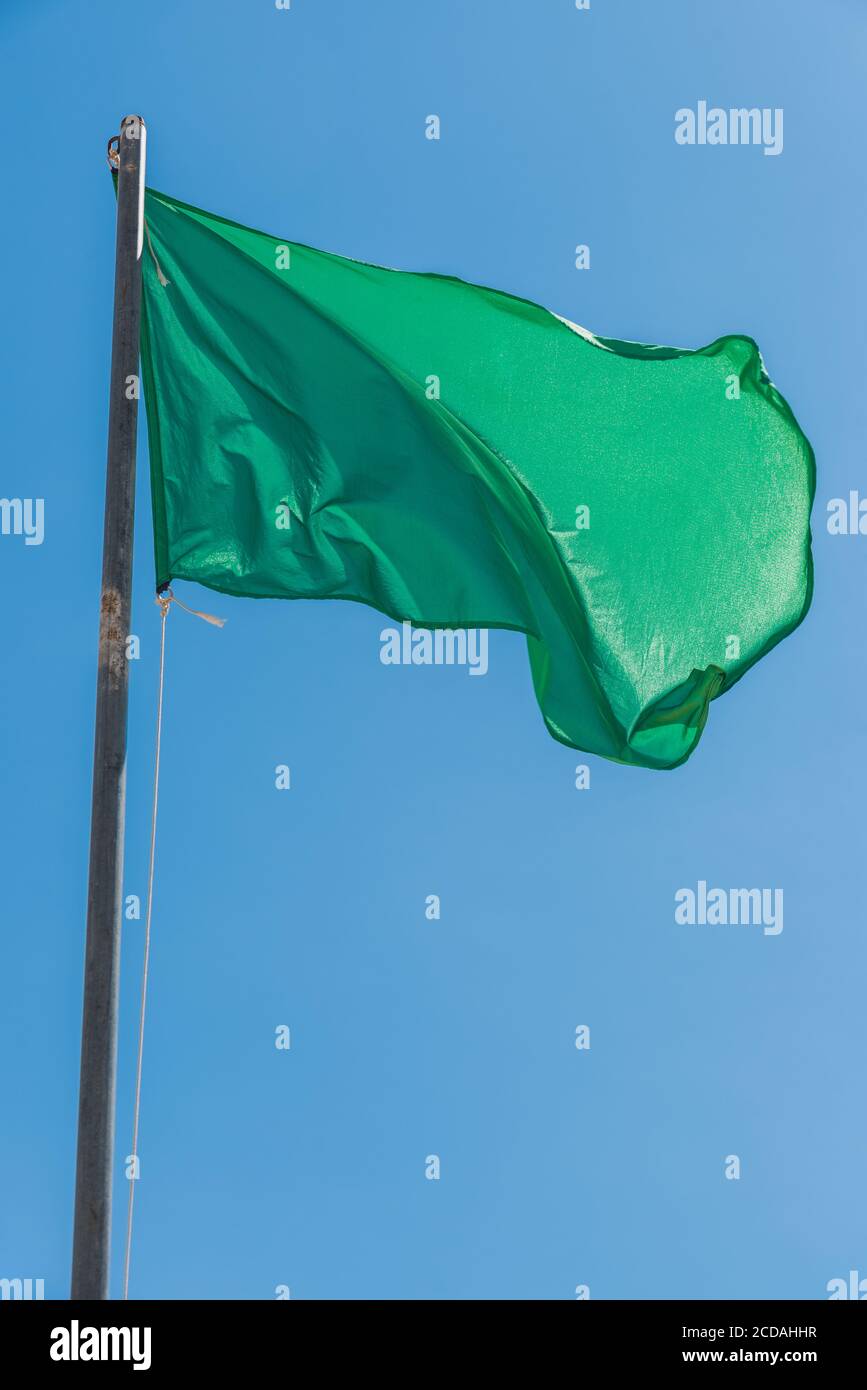 Waving green flag indicating the calmness of the sea Stock Photo - Alamy