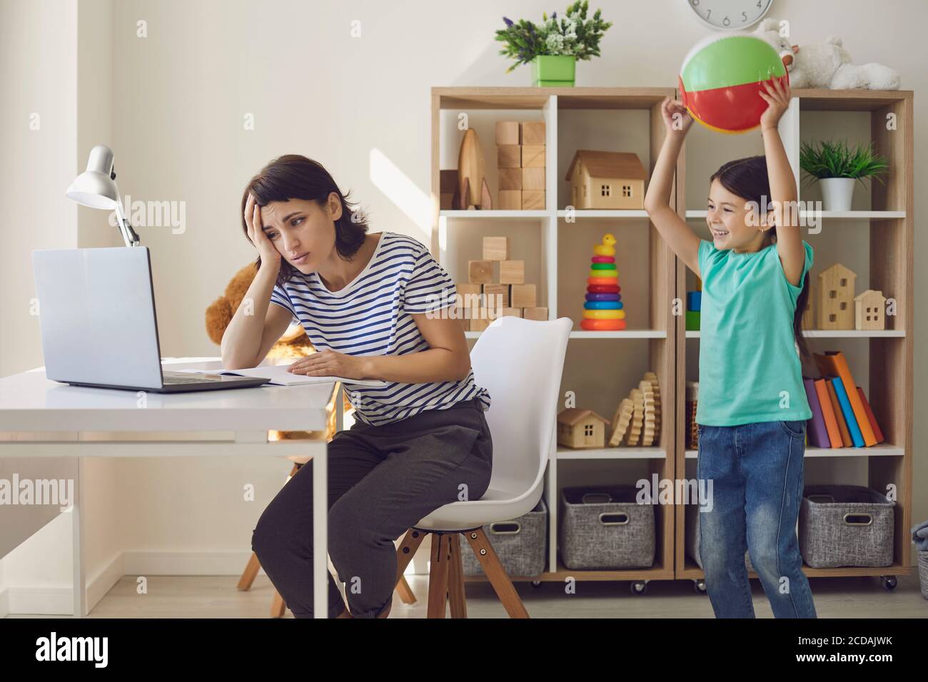 Mother Sitting With Laptop And Trying To Work While Her Smiling