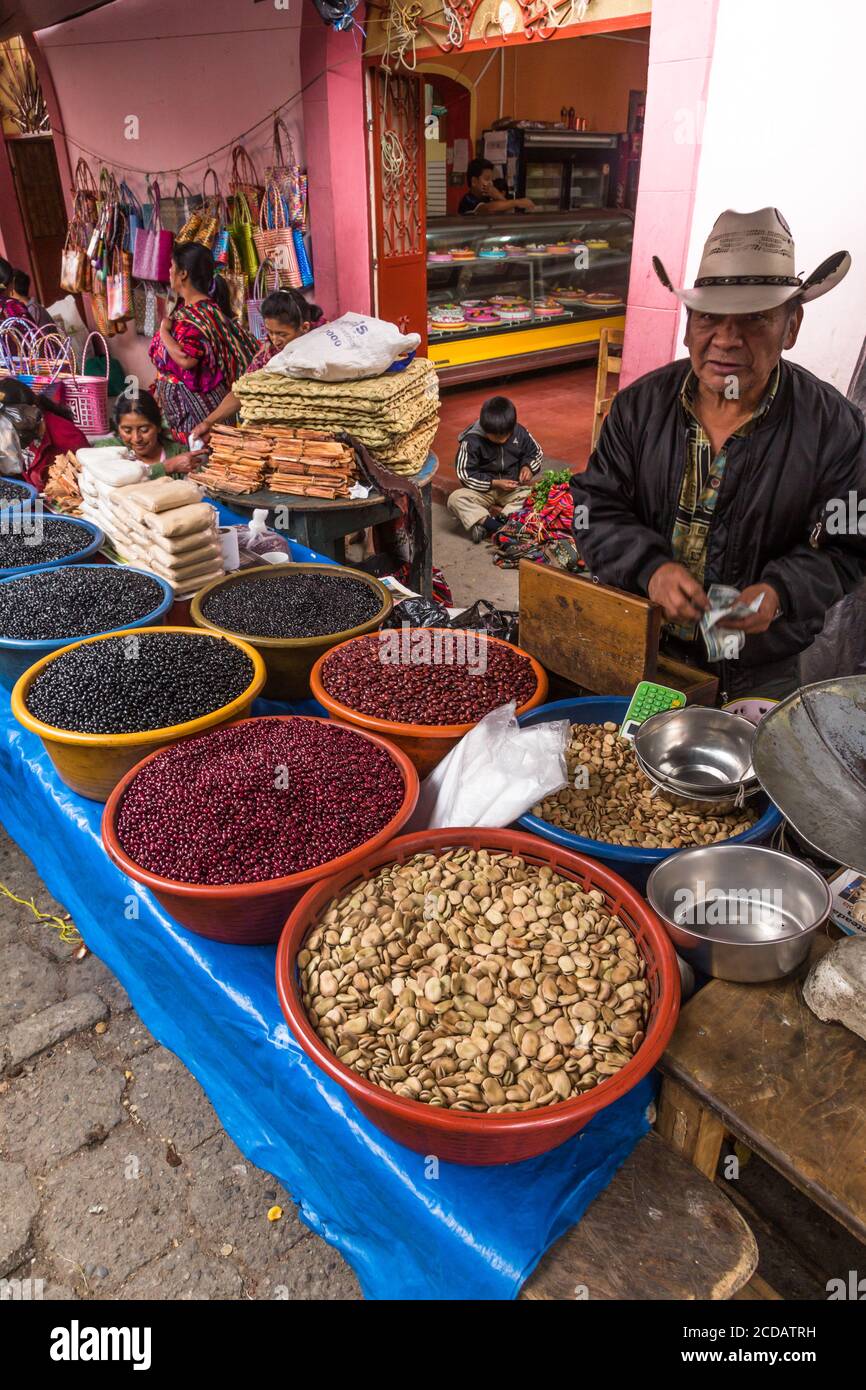 A Quiche Mayan man sells produce in the market in front of the Church ...