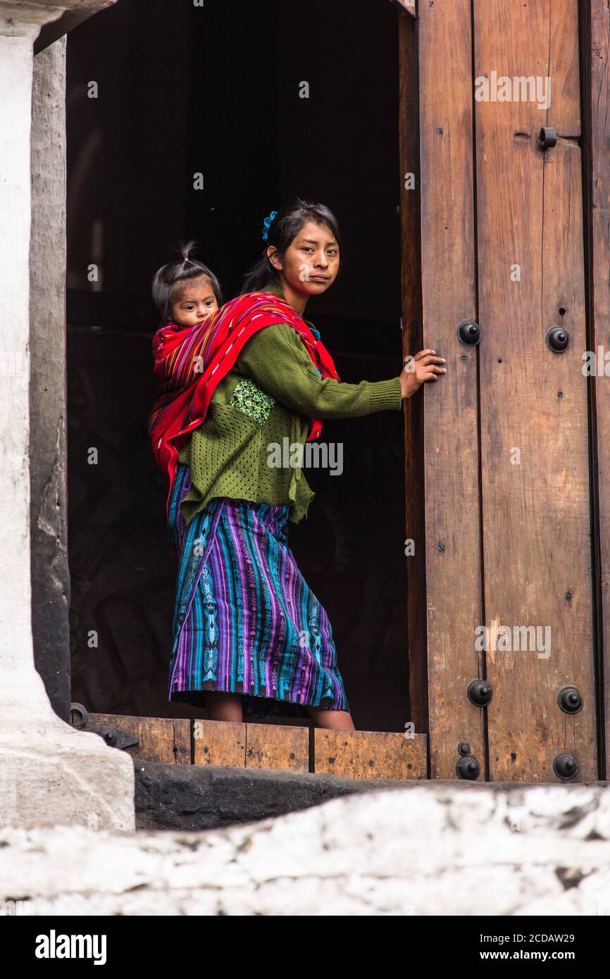 A young Quiche Mayan woman, in traditional dress, and her daughter ...