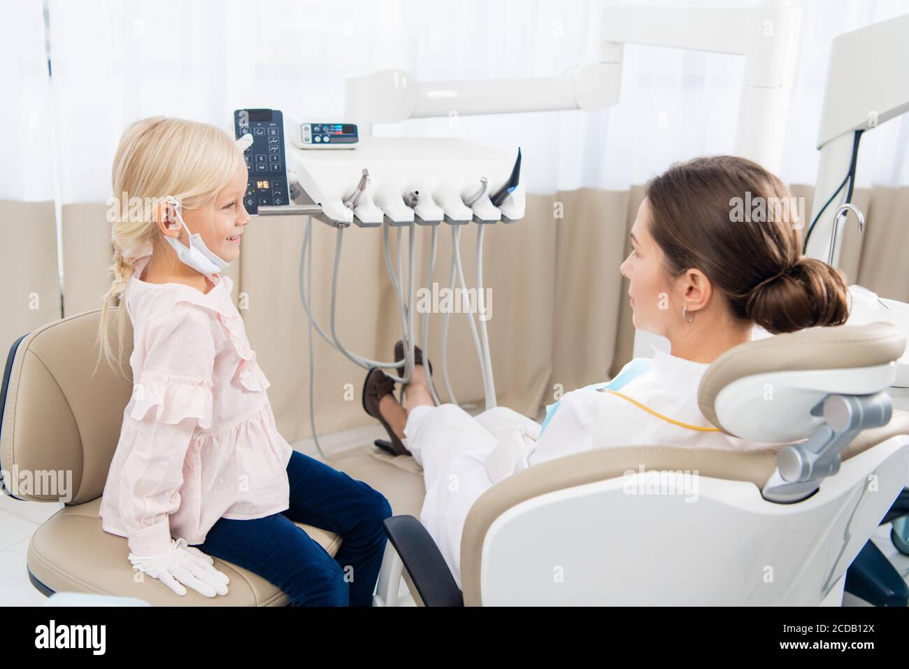 Little cute girl performing a dental check up of her doctor. Kids ...
