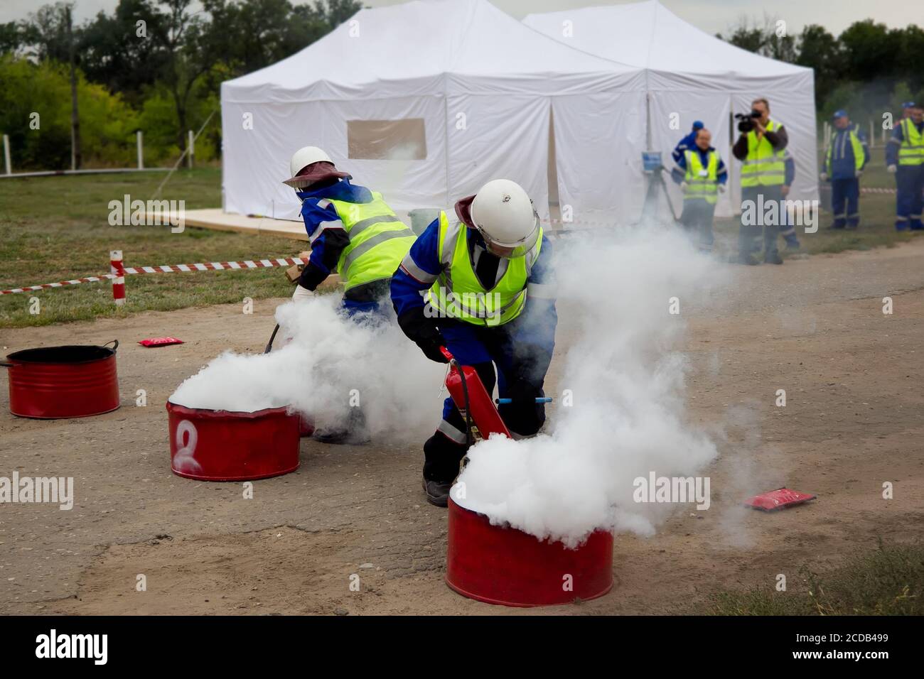 Firefighters on training. Firemen using use a fire extinguisher on a ...