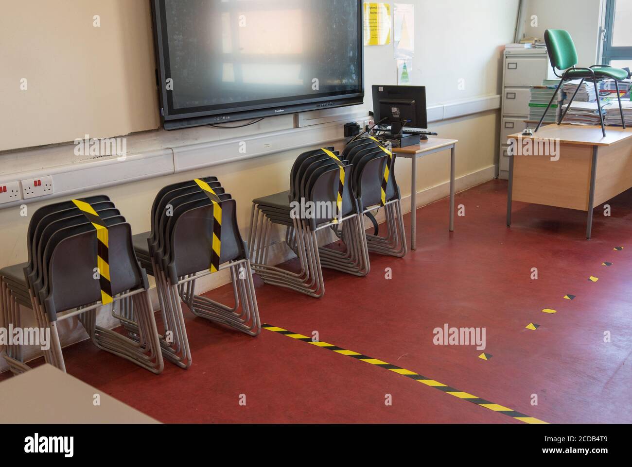 Social distancing measures in a school classroom with tape separating ...