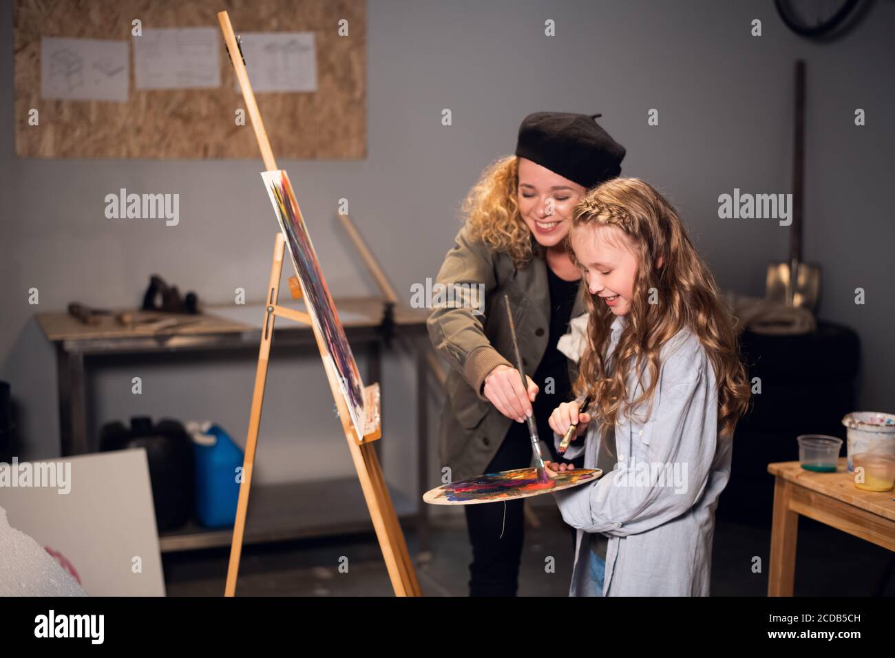 Joint work of two artists. Young funny girls draw a picture in the ...