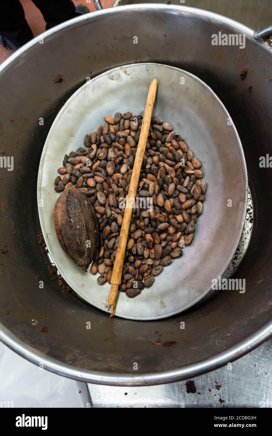 A cacao pod, roasted cacao beans, and a stick of natural cinnamon for ...