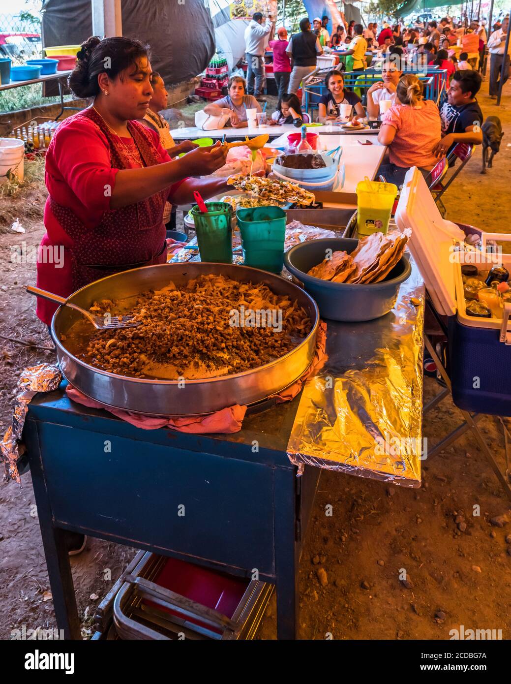 A cook preparing ground pork tostadas at the Guelaguetza folk dance ...