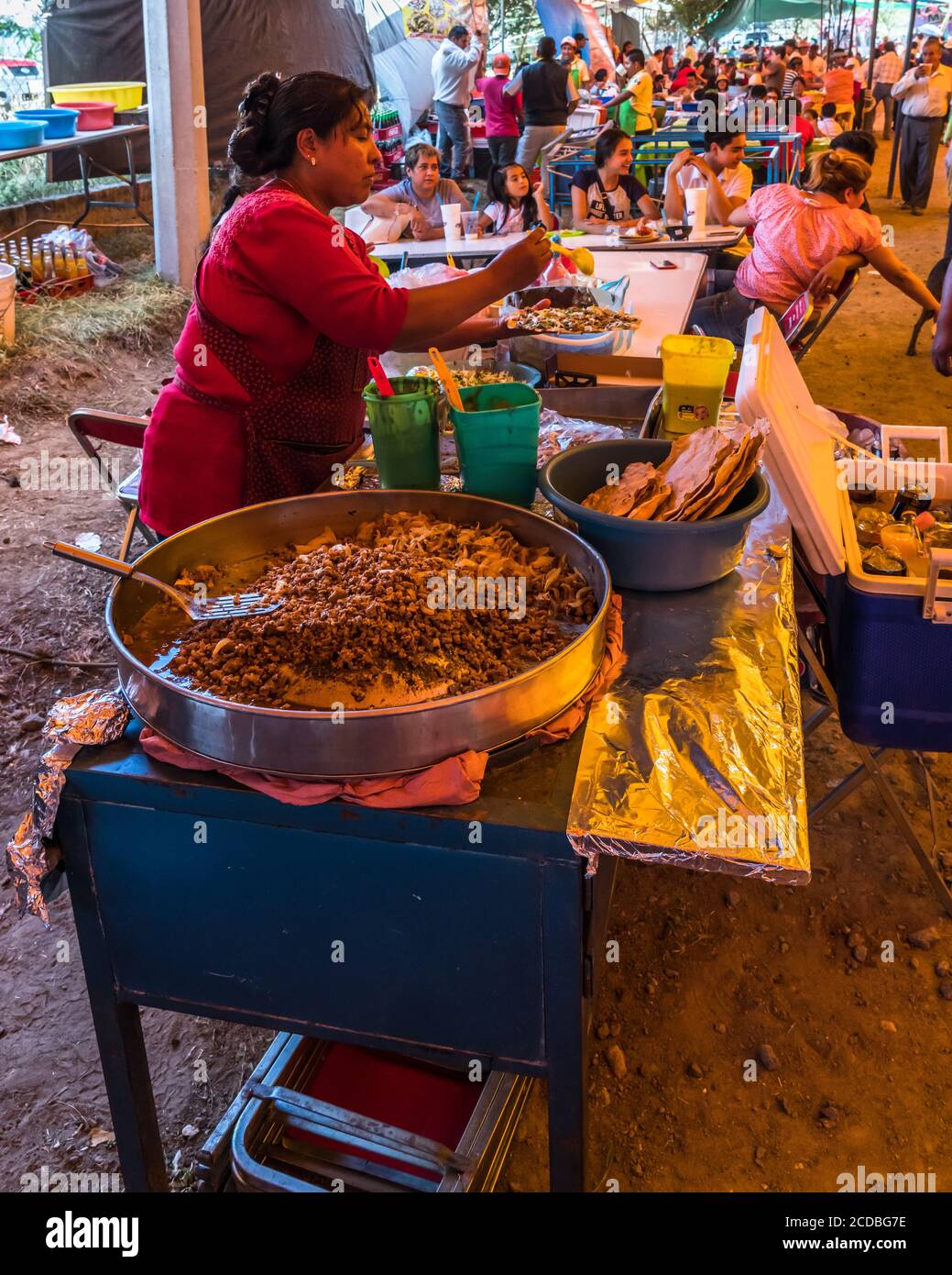 A cook preparing ground pork tostadas at the Guelaguetza folk dance ...