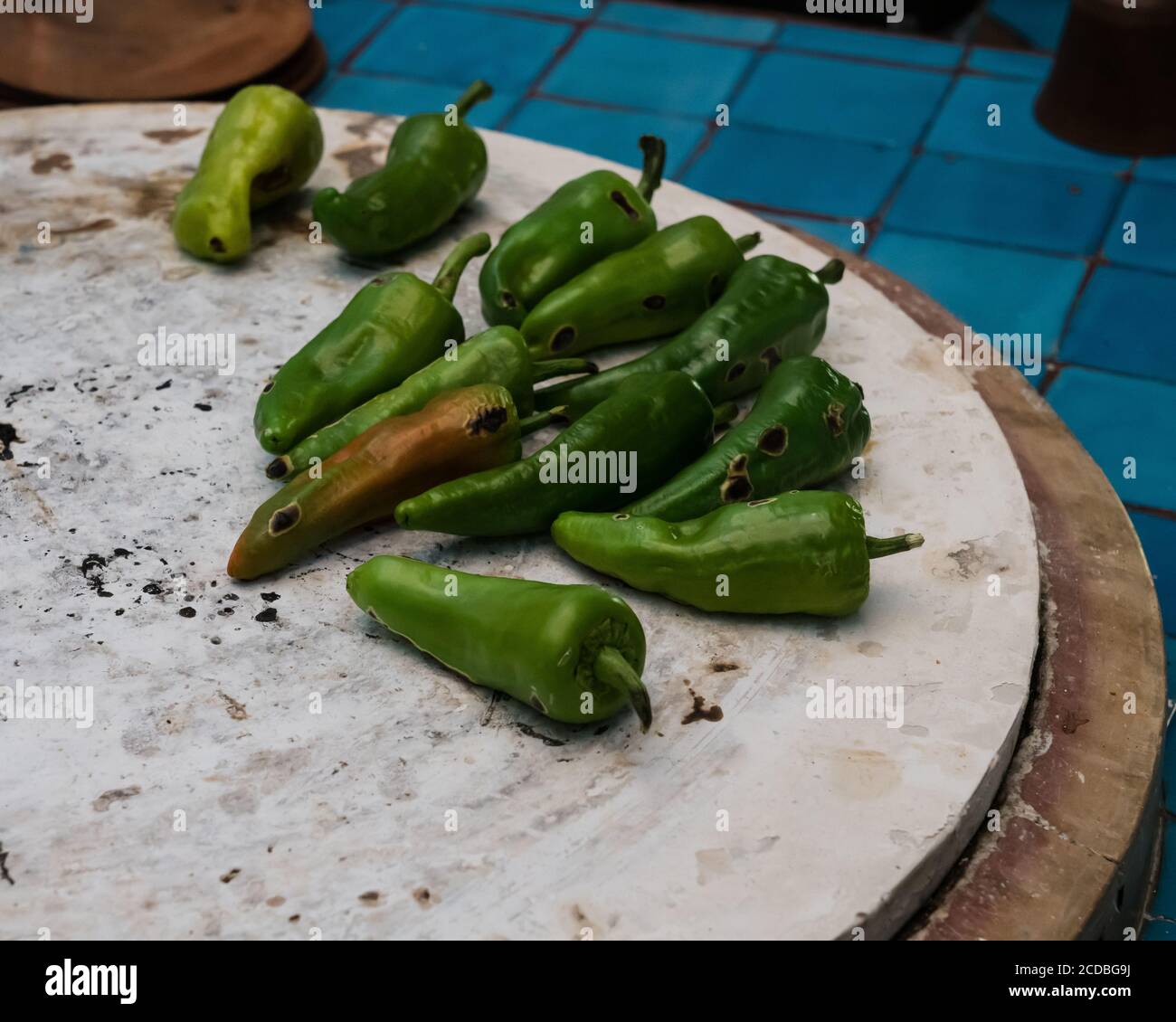 Hot chile peppers roasting on a traditional comal in a restaurant in ...