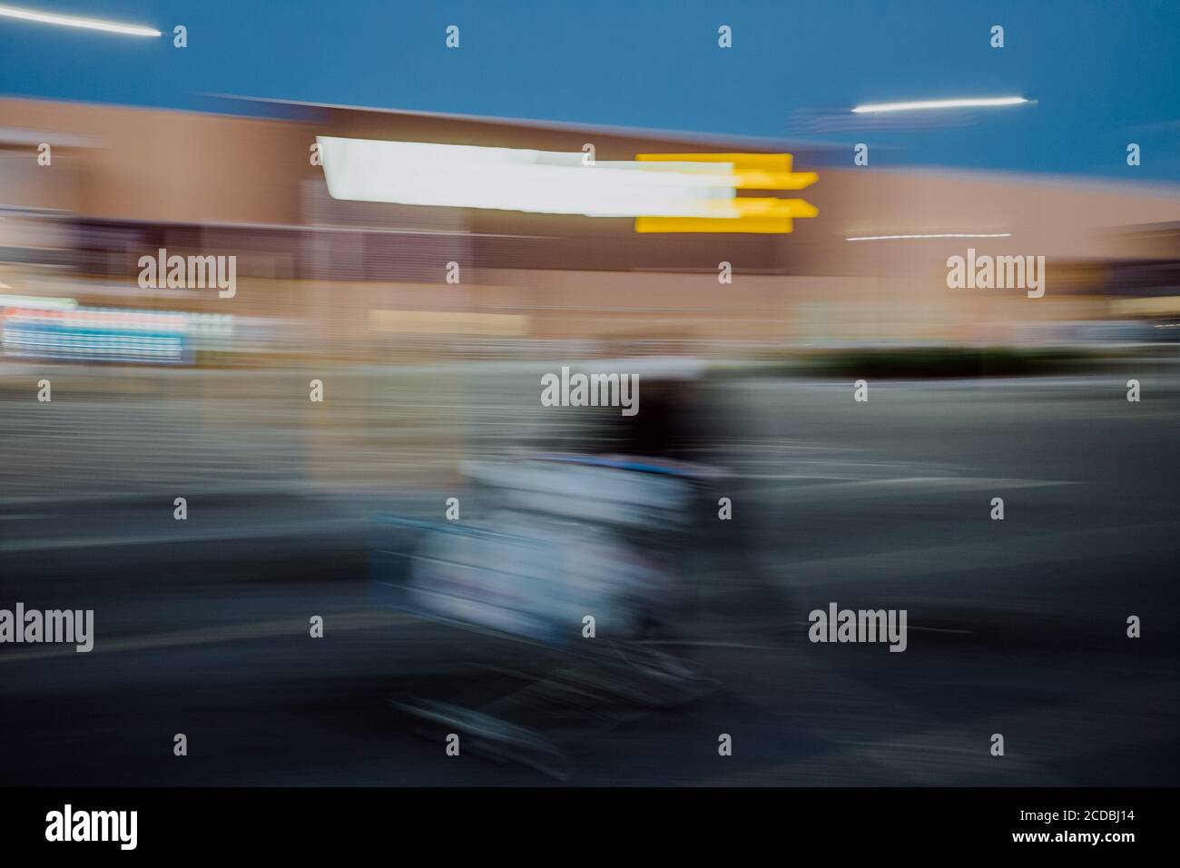 Frantic shopper pushing shopping cart outside store Stock Photo - Alamy
