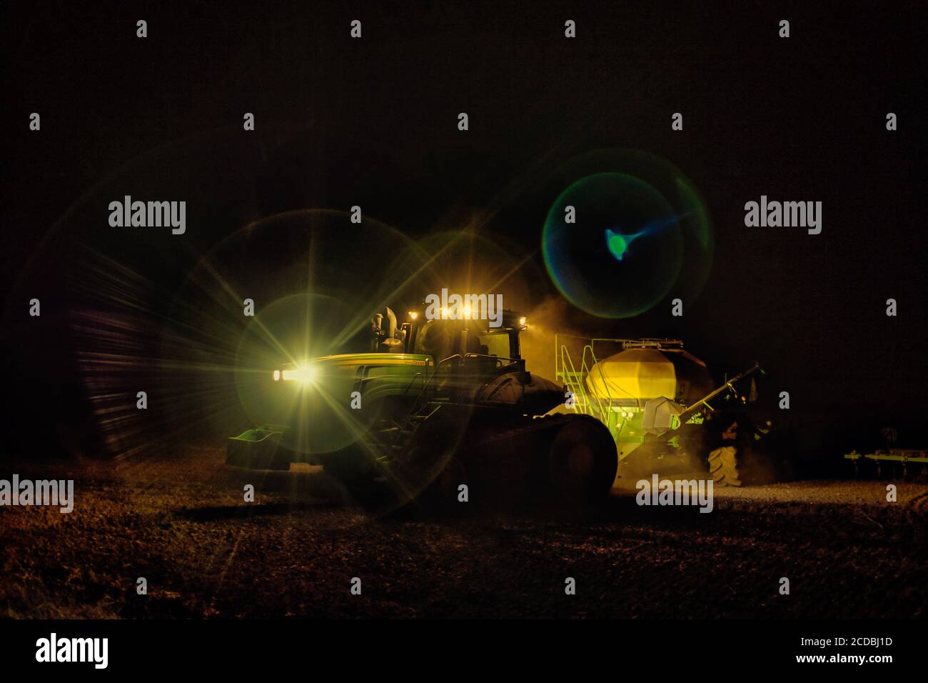 Farmer working the field at night with John Deere tractor Stock Photo ...