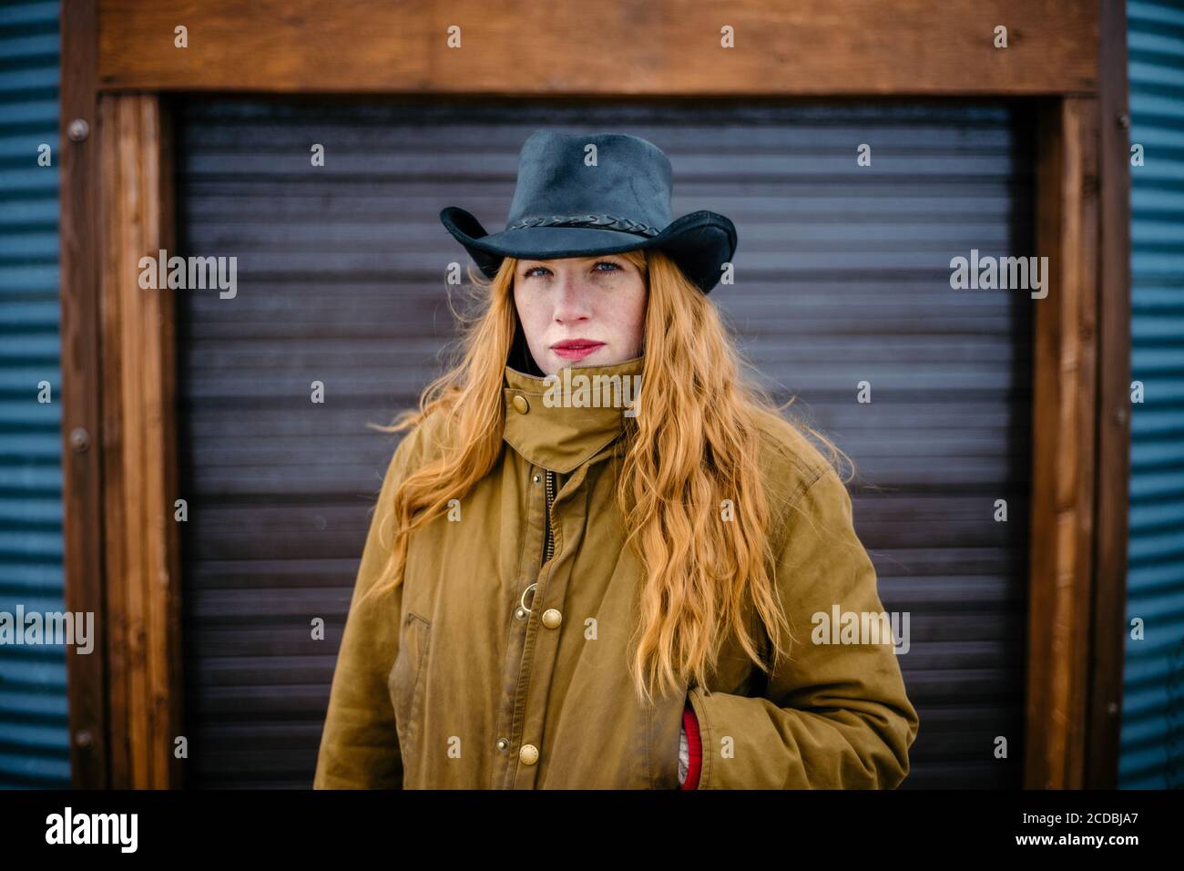 Confident western woman with cowboy hat walks around the snow with her ...