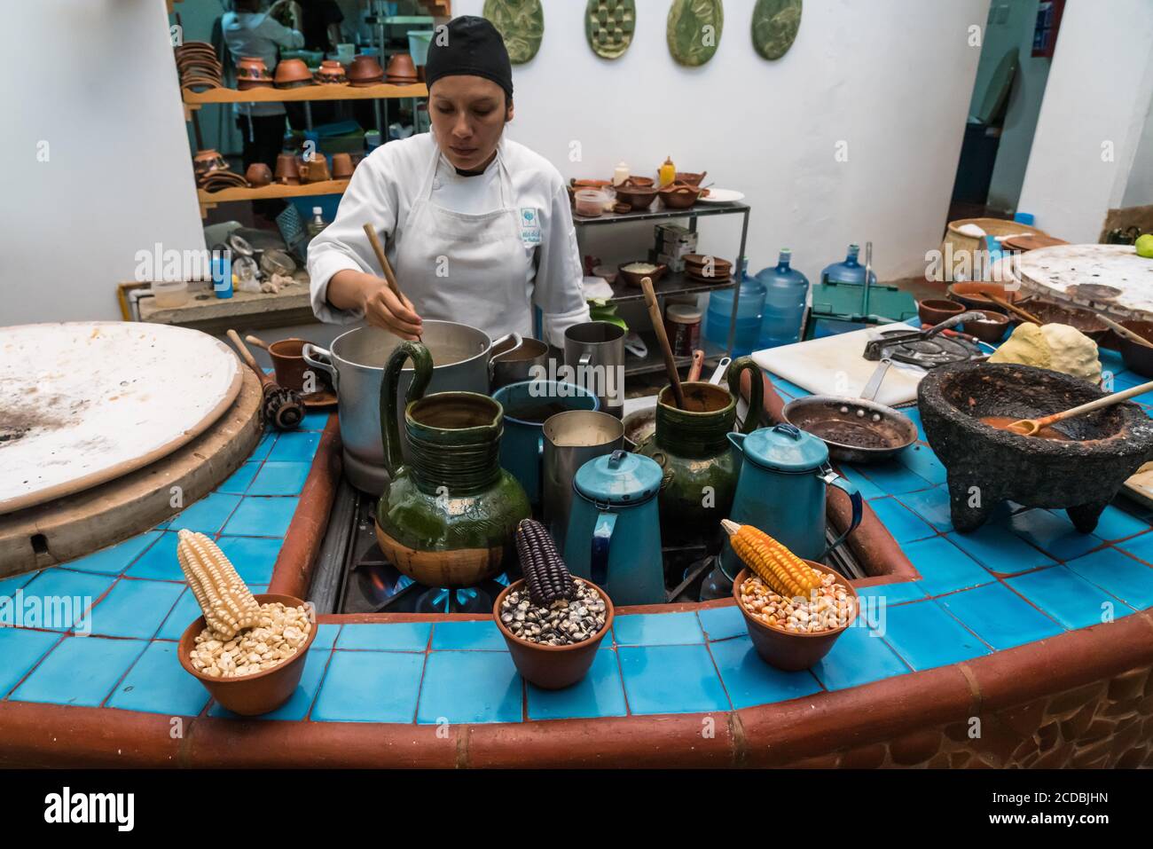 A chef cooks in restaurant in Oaxaca, Mexico. In front are white, blue ...
