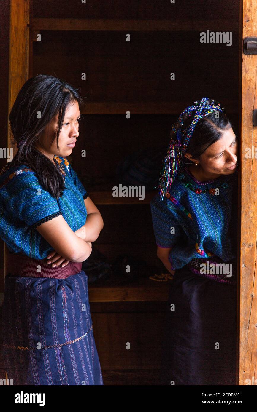 Two Mayan women peer out the door of the Saint Anthony of Padua Church ...