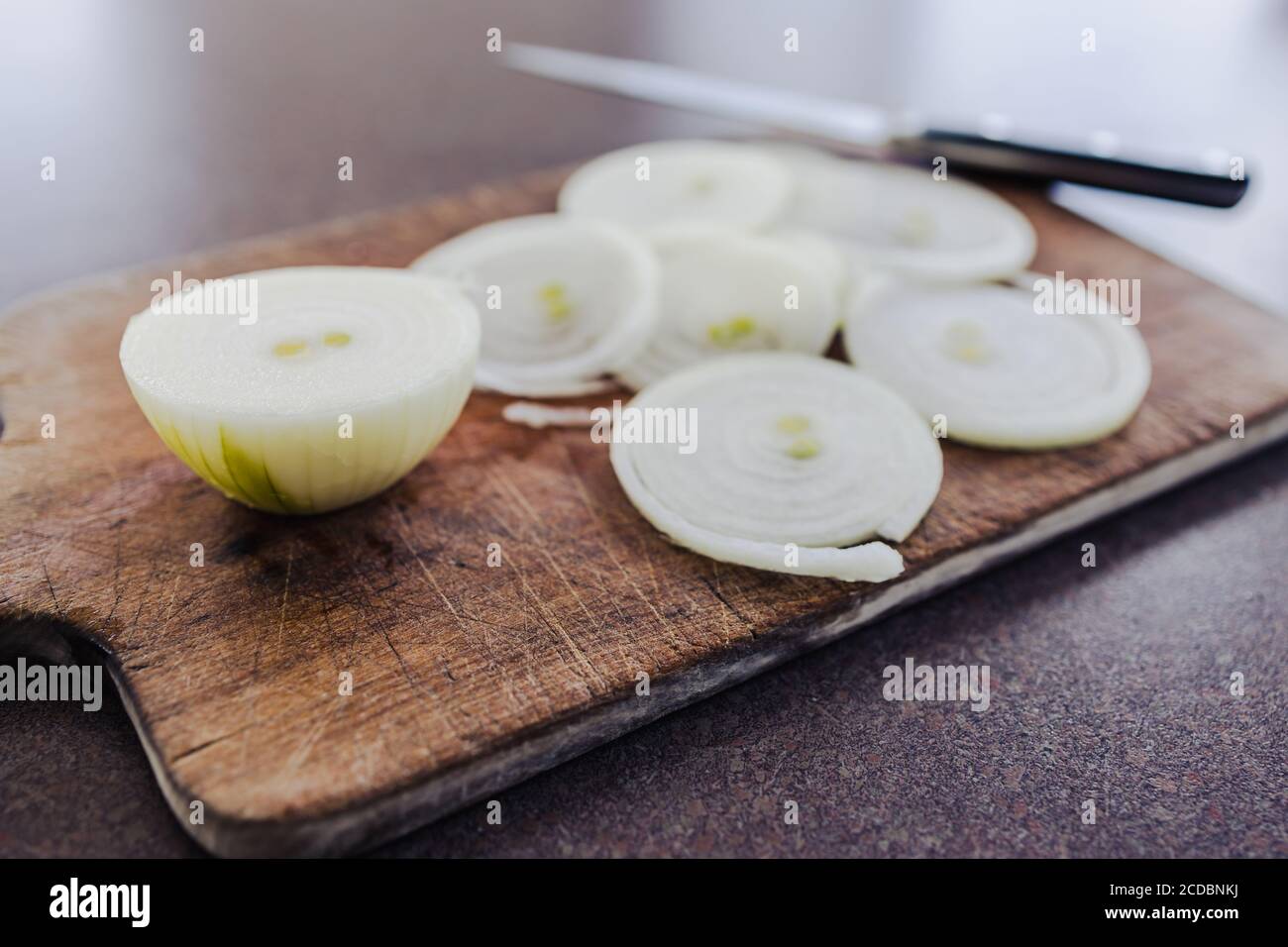 simple food ingredients concept, fresh onion cut into rings on cutting ...