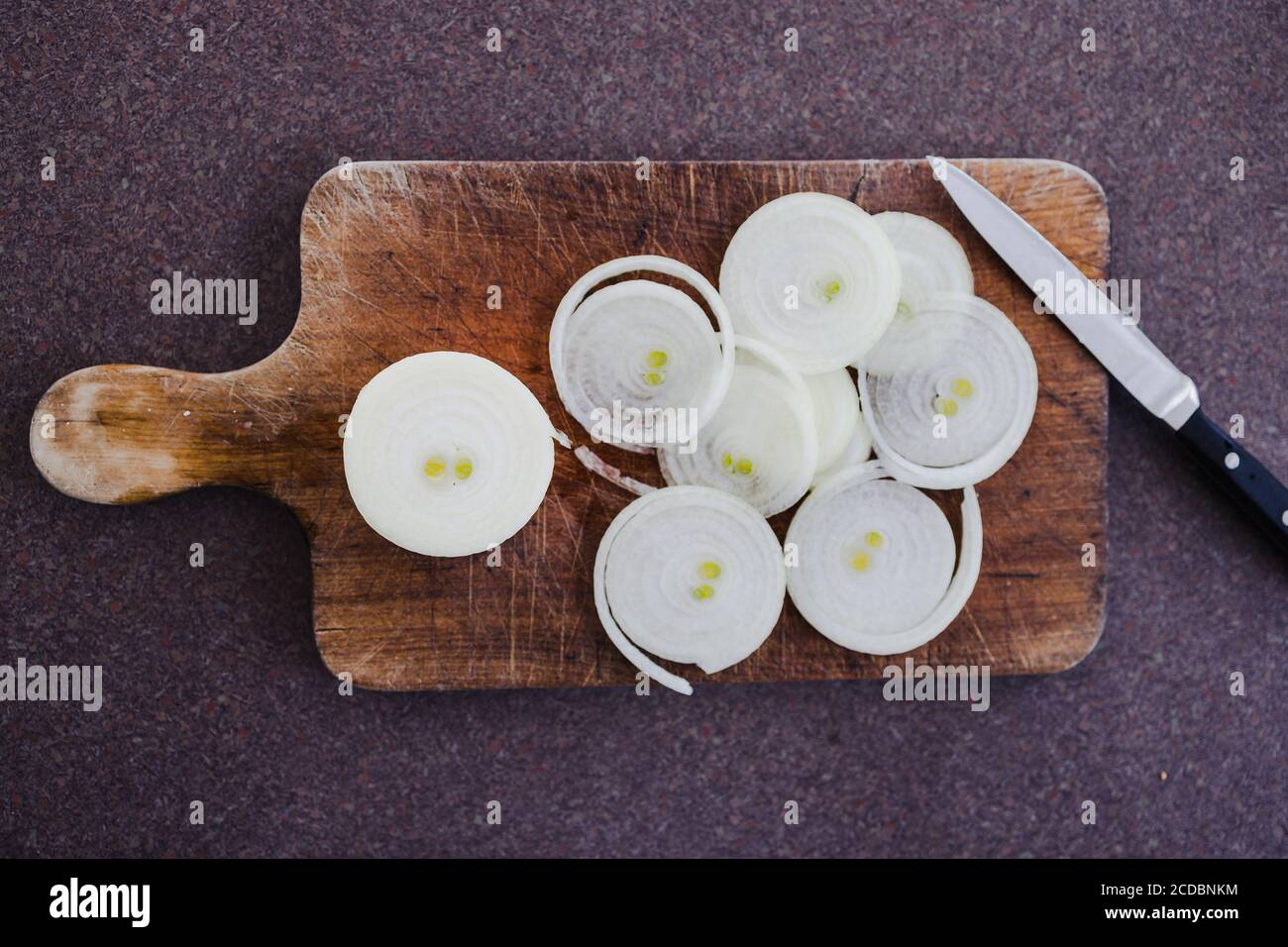 simple food ingredients concept, fresh onion cut into rings on cutting ...