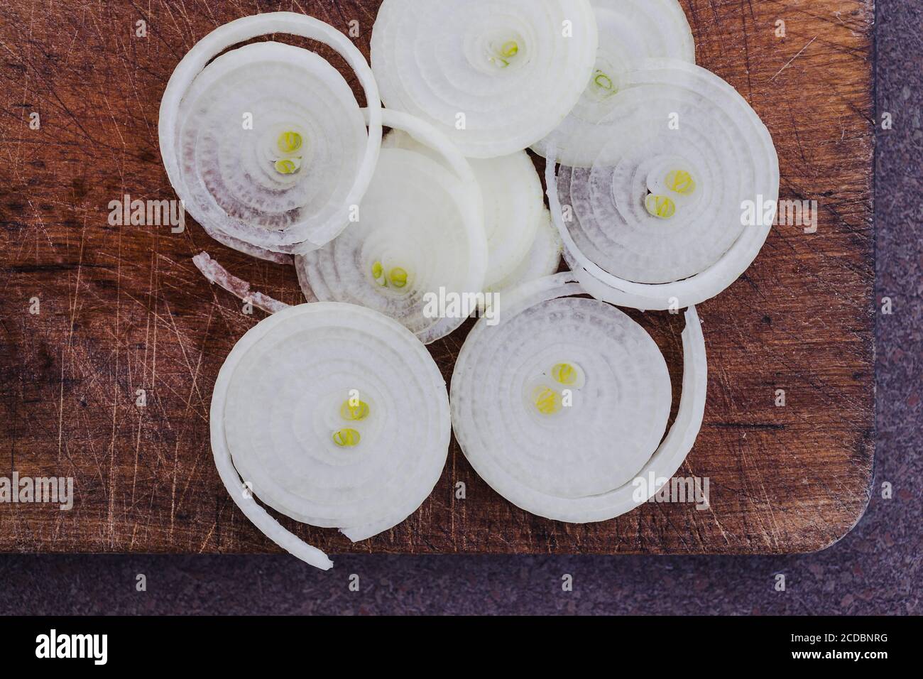 simple food ingredients concept, fresh onion cut into rings on cutting ...