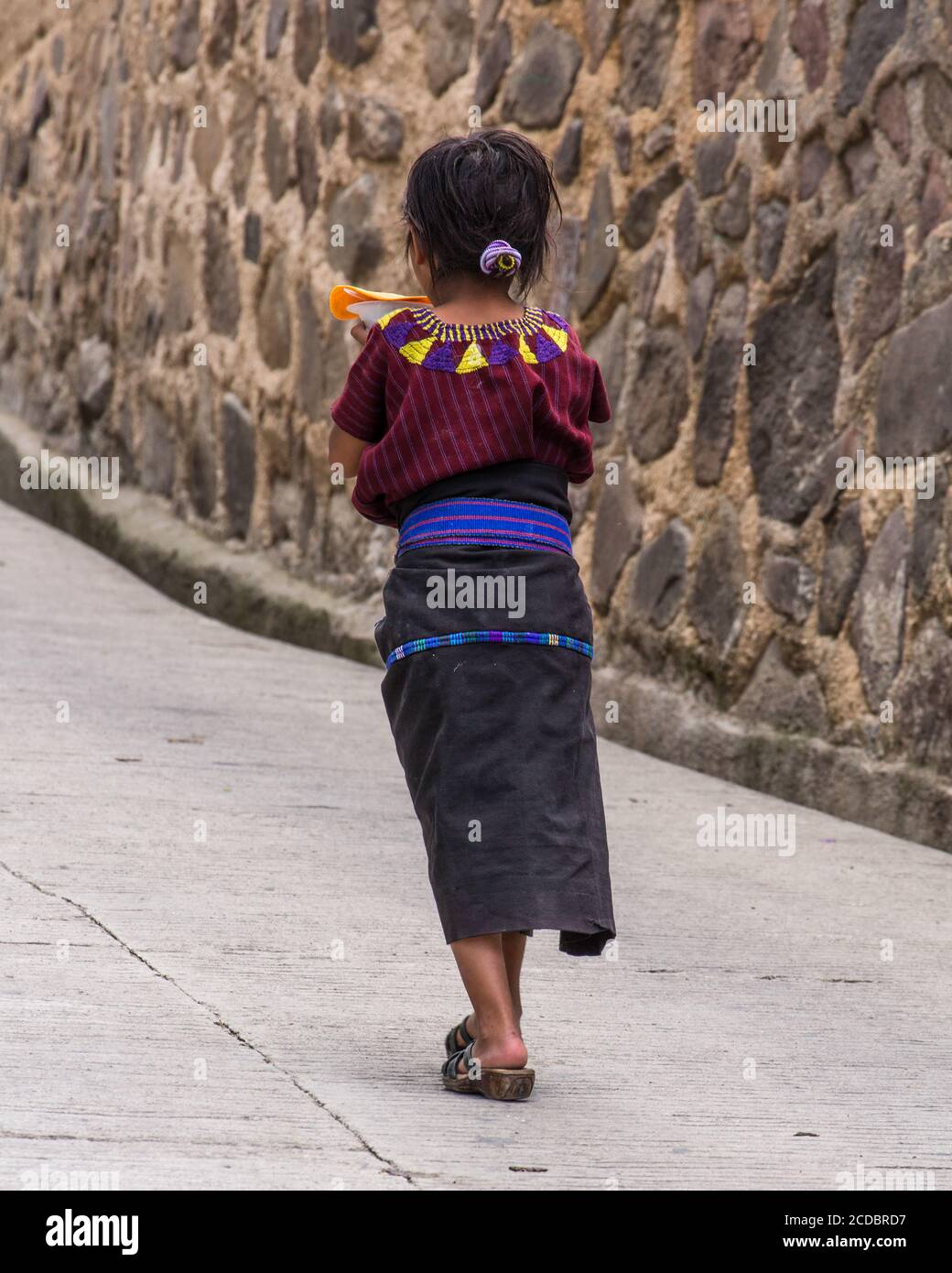 A young Cakchiquel Mayan girl wearing traditional dress wall up the ...