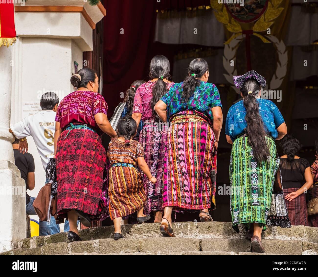 Tzutujil Mayan women and children in traditional dress enter the Church ...