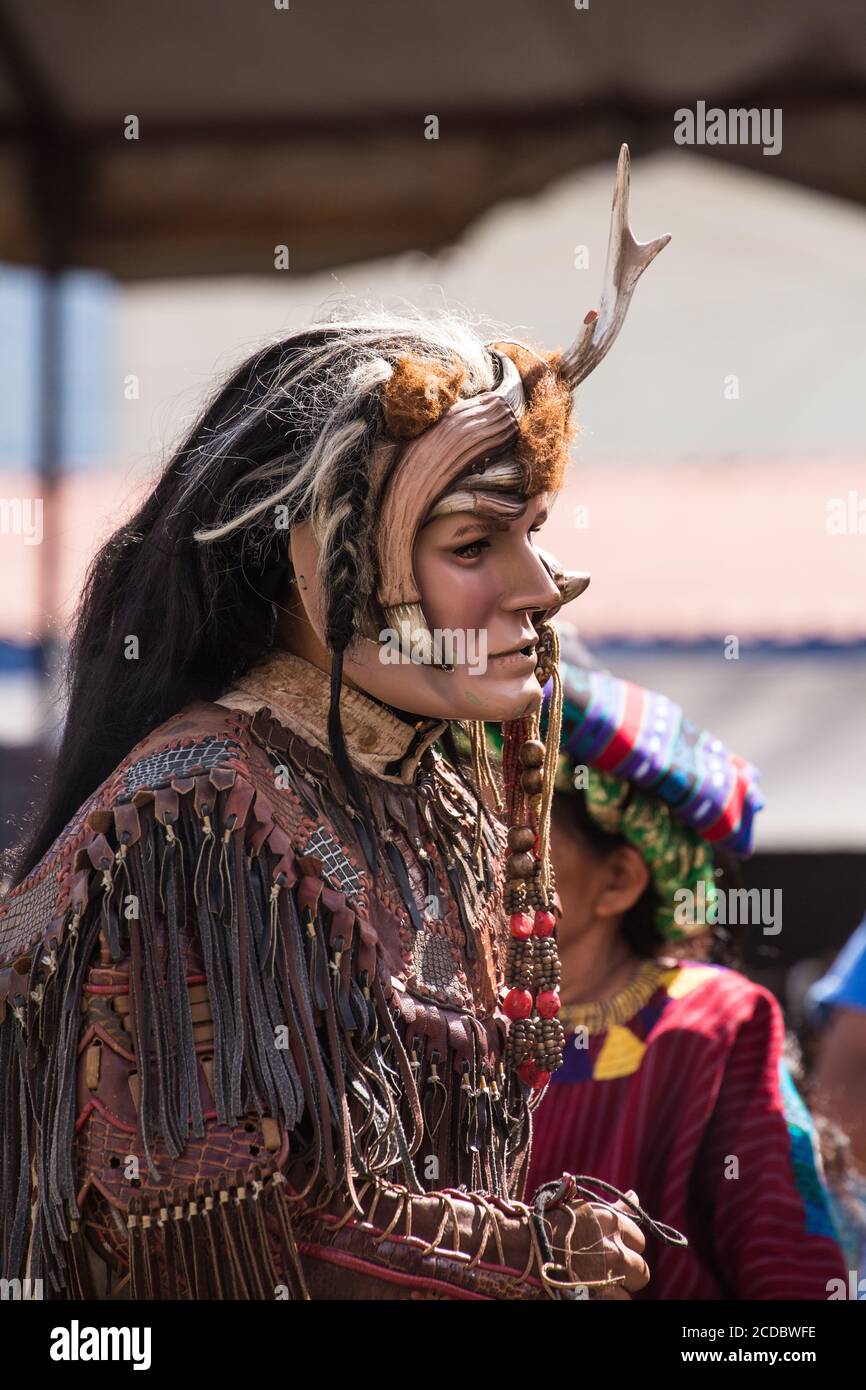 A masked and costumed dancer performs for the Festival of Santiago in ...