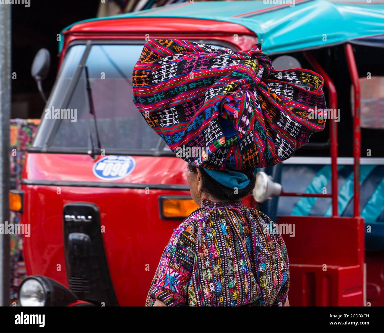 An older Tzutujil Mayan woman in traditional dress walks on a street in ...