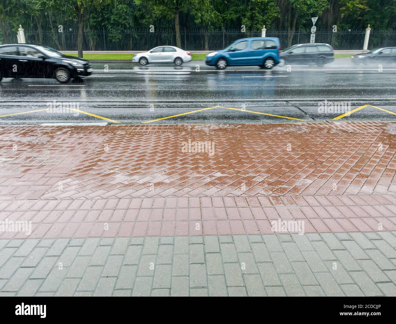 traffic in the city on a rainy day. cars crossing a flooded road during ...