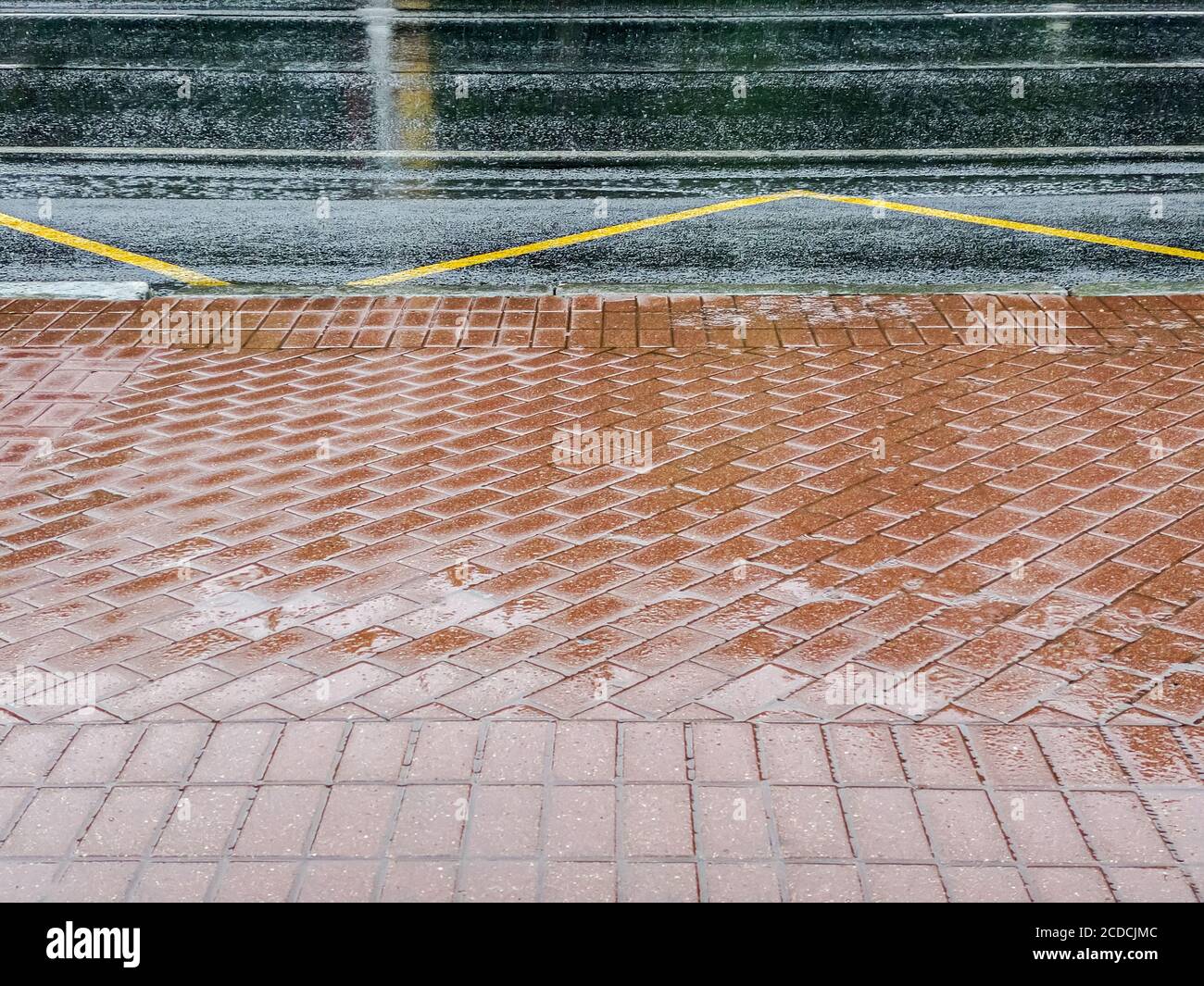 rainy background with wet red cobblestone pavement and flooded dark ...