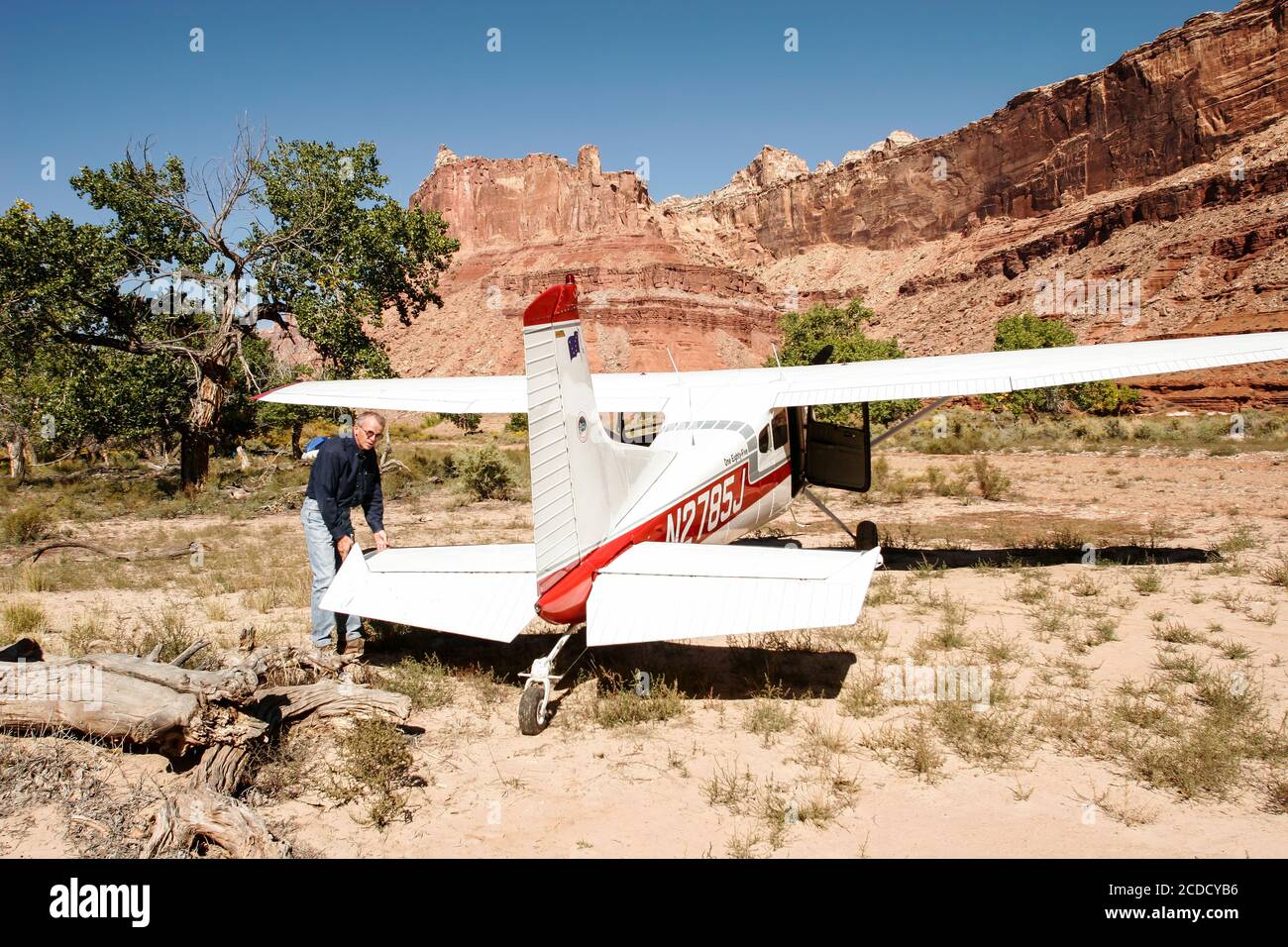 The pilot checks over his Cessna 185 Skywagon of the Utah Backcountry ...