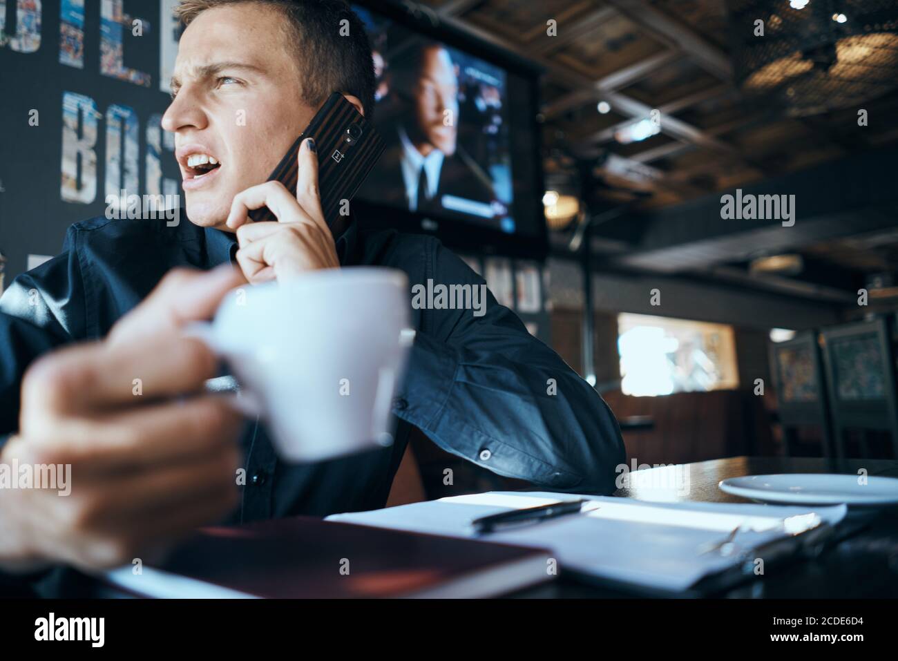 Business man with a cup of coffee in a cafe emotions work in the office ...