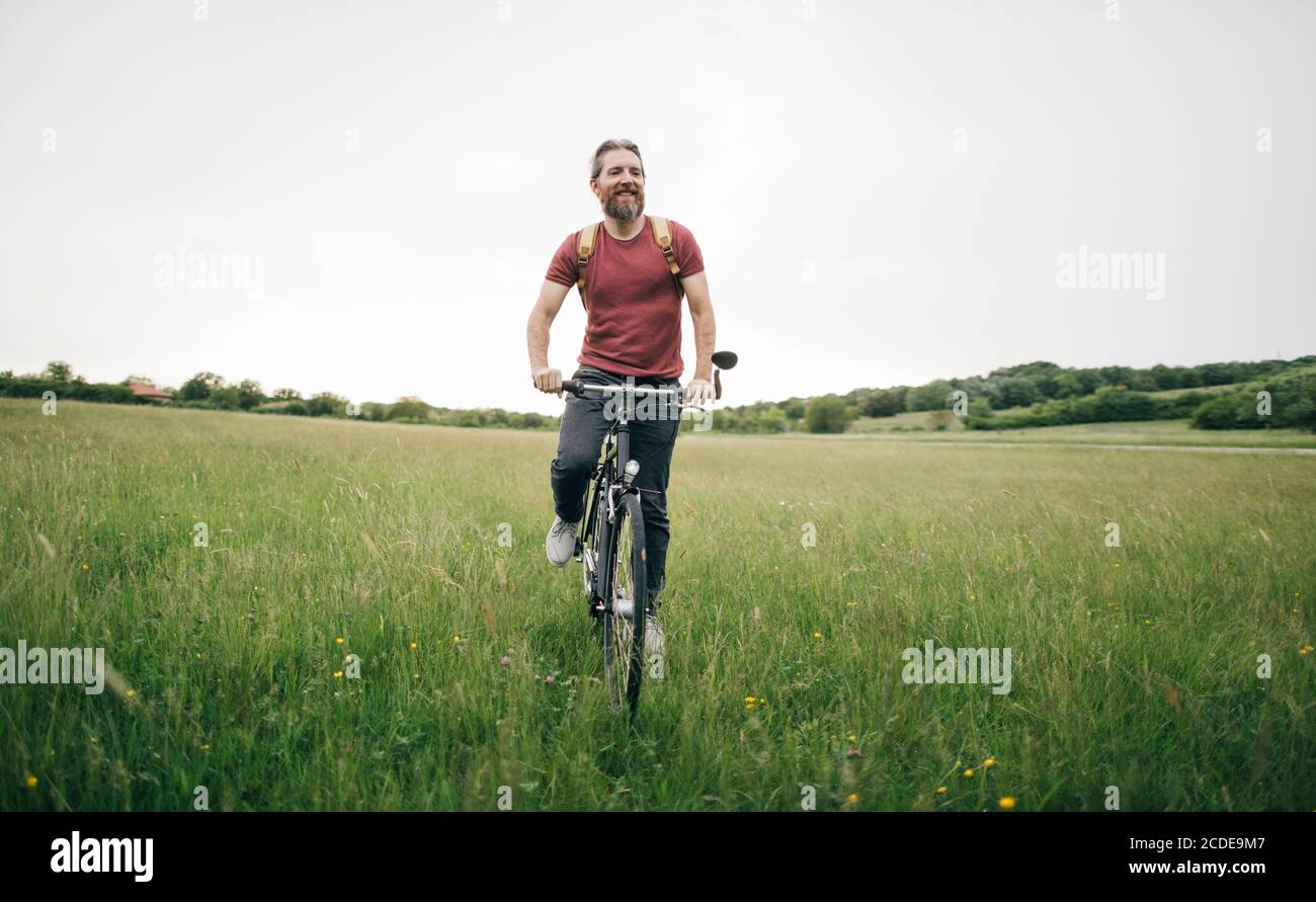 Bearded man riding a bike in nature Stock Photo - Alamy