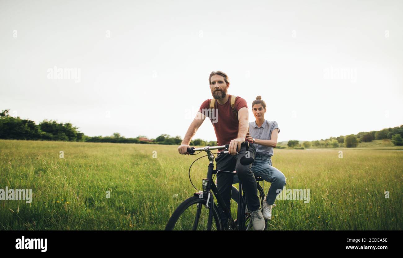 Romantic couple is riding a bike together outdoors Stock Photo - Alamy