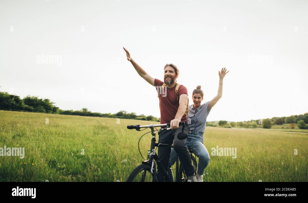 Romantic couple is riding a bike together outdoors Stock Photo - Alamy