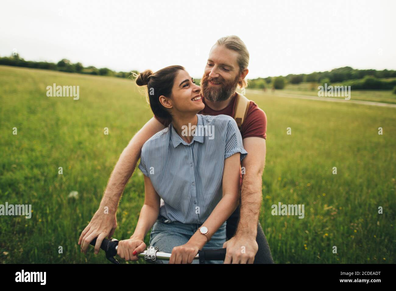 Romantic couple is riding a bike together outdoors Stock Photo - Alamy