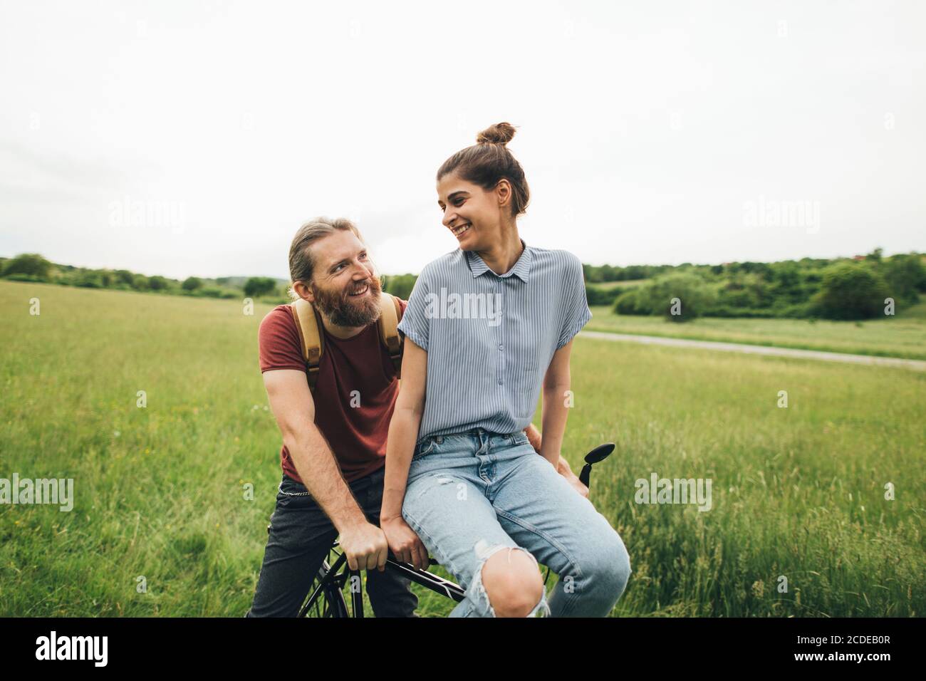 Romantic couple is riding a bike together outdoors Stock Photo - Alamy