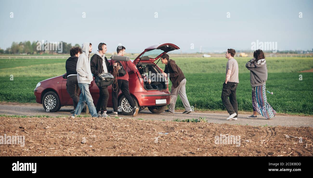 Behind scene improvisation. Film crew team pushing car while cameraman ...