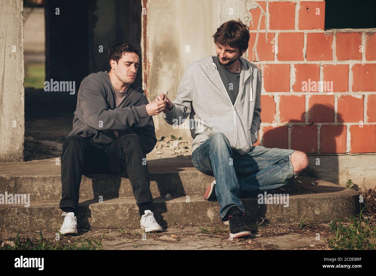 Young urban friends smoke marihuana or hashish joint in underground ...